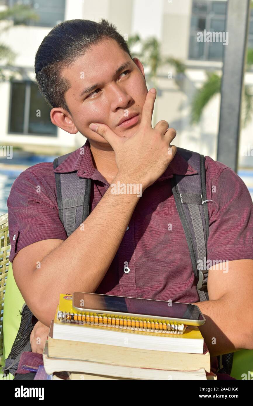 Diverse Boy Student Thinking With Books Stock Photo - Alamy