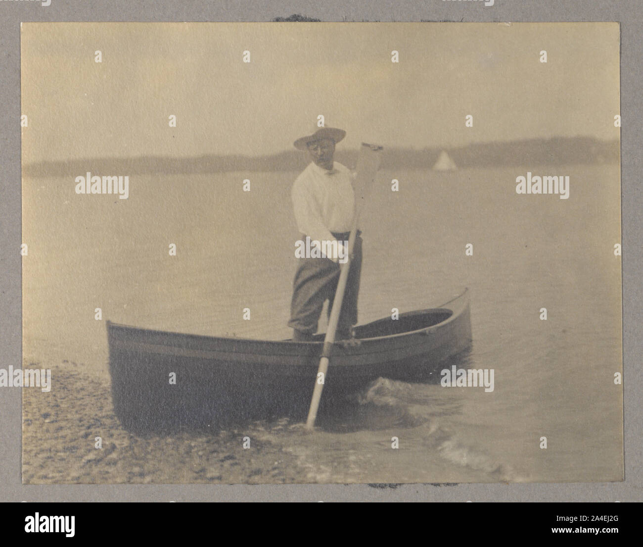Theodore Roosevelt, standing up in canoe, pushing away from shore with ...