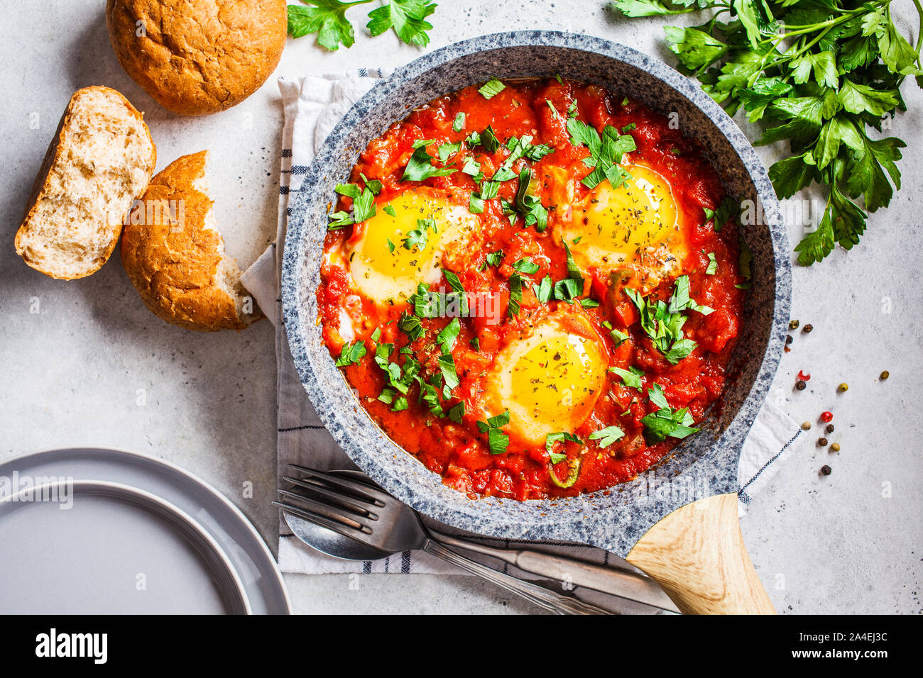 Traditional shakshuka in a pan. Fried eggs in tomato sauce with herbs ...