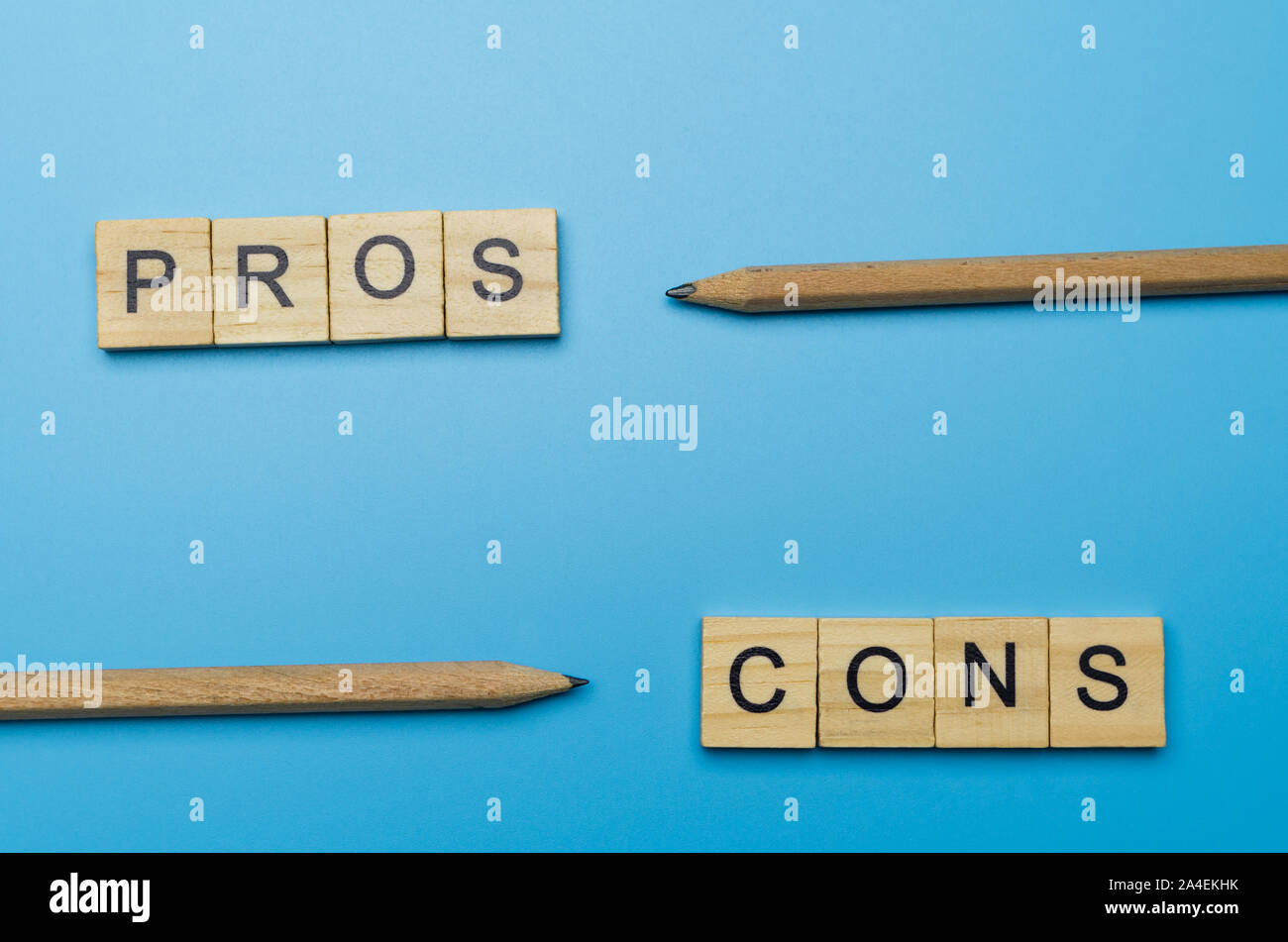 "Pros and Cons" word in the wooden block on blue background pointed by ...