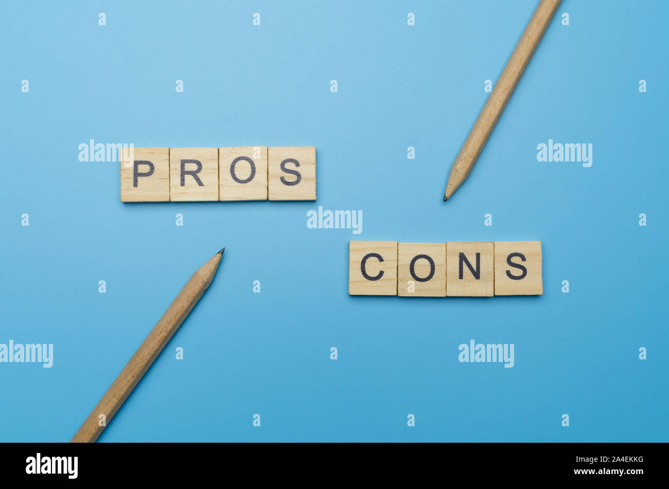"Pros and Cons" word in the wooden block on blue background pointed by ...