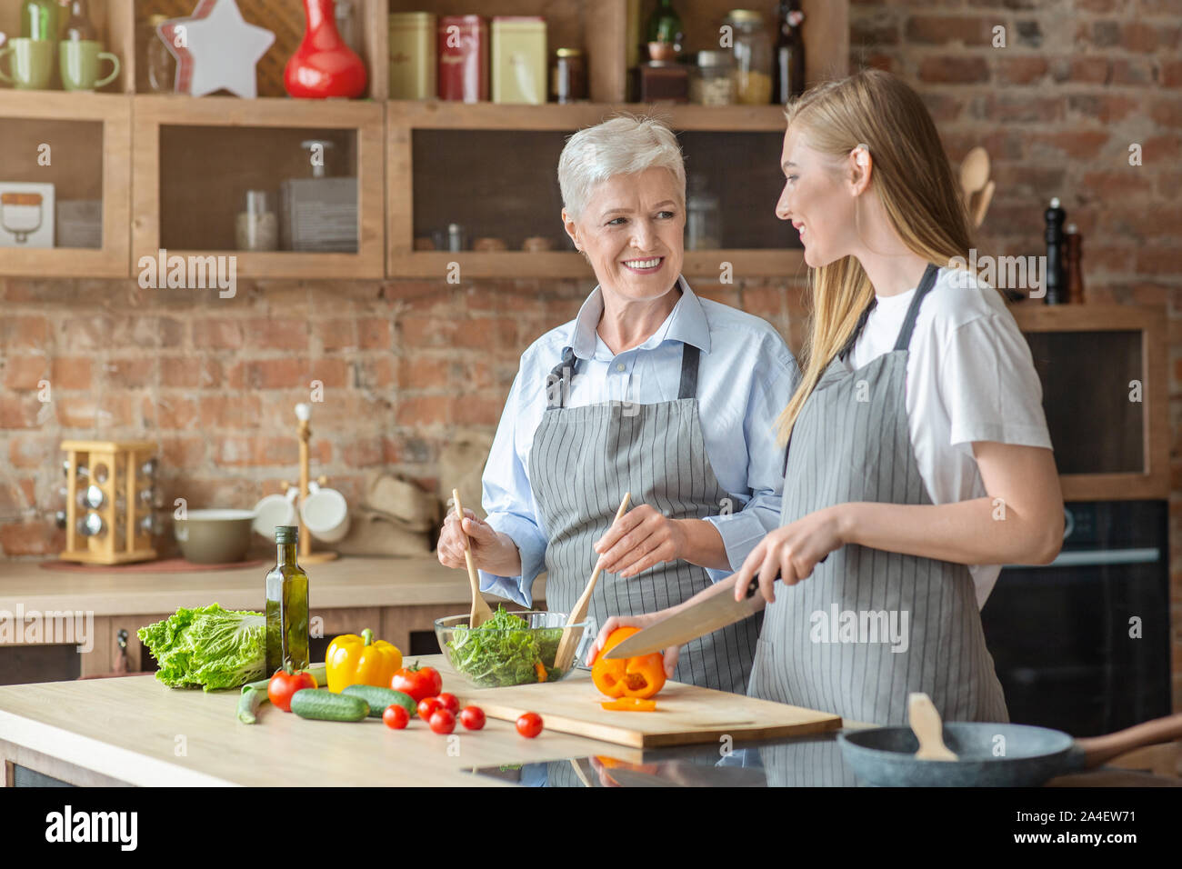 Friendly mother and daughter making healthy dinner together Stock Photo ...