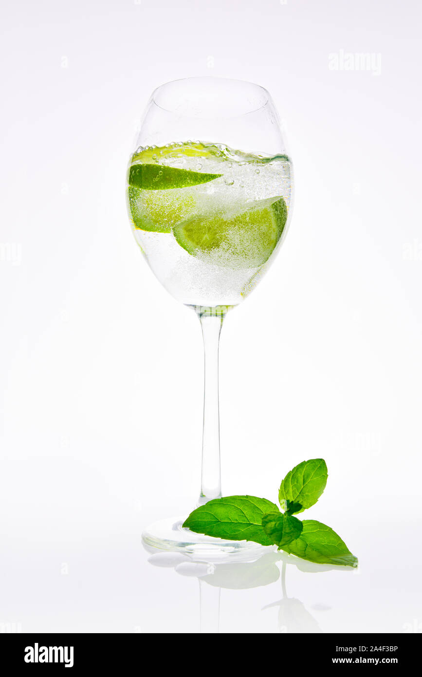 Lime in carbonated water with a mint leaf. White background Stock Photo - Alamy