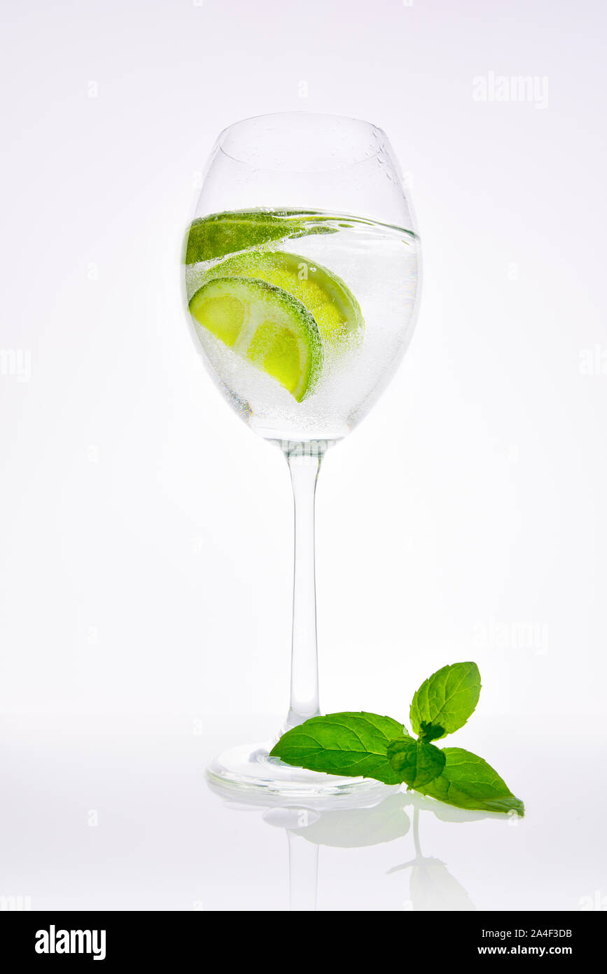 Lime in carbonated water with a mint leaf. White background Stock Photo - Alamy