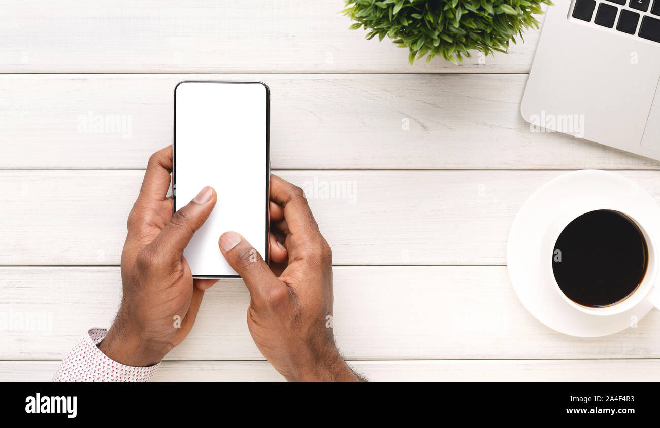 Black hands using modern cellphone with blank screen at workplace Stock ...