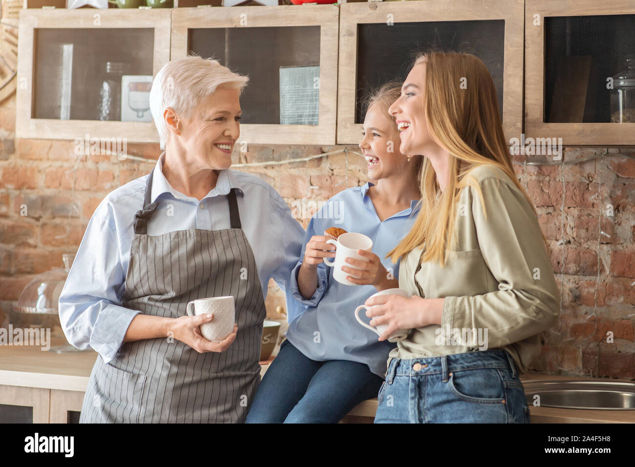 Female family drinking tea and talking at kitchen Stock Photo - Alamy
