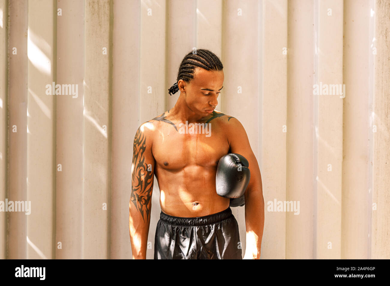 Tired boxer standing with gloves at the wall looking down Stock Photo ...