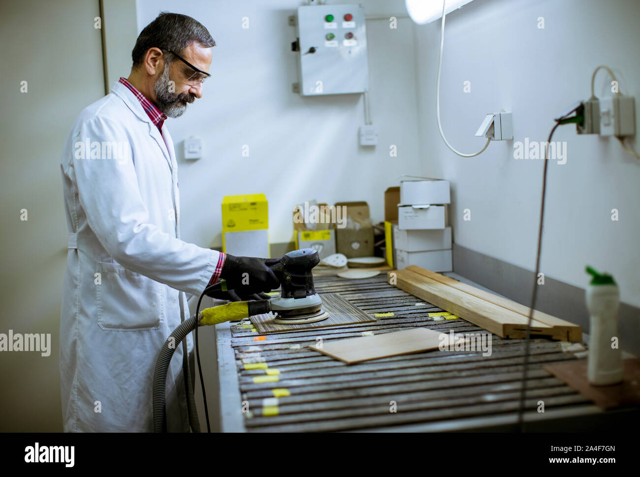 View at handsome senior engineer in the laboratory examines ceramic ...