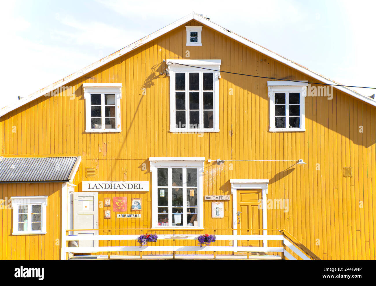A bright yellow timber building in the fishing village of Nusfjord ...
