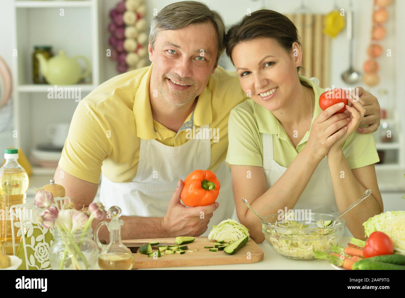 Happy husband and wife cooking together in the kitchen Stock Photo - Alamy