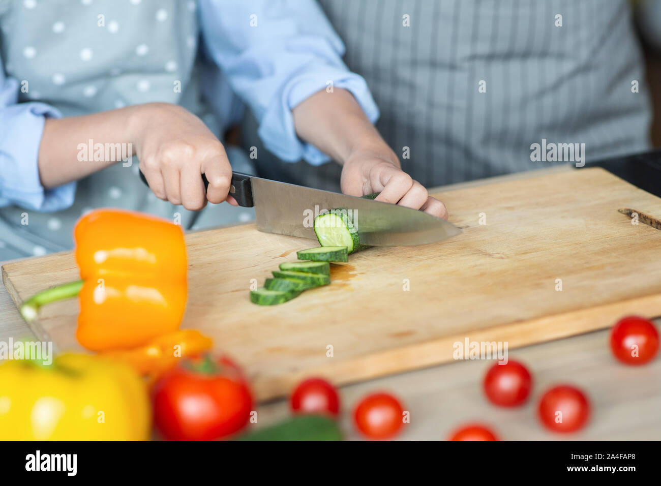 Hands of girl learning how to cut vegetables Stock Photo - Alamy