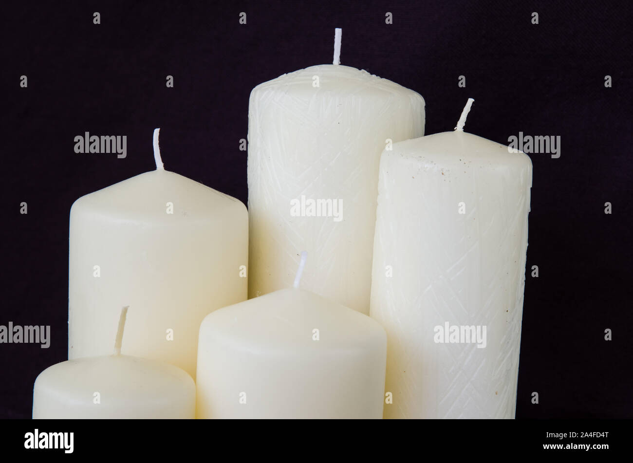 group of unlit white candles against black background Stock Photo - Alamy