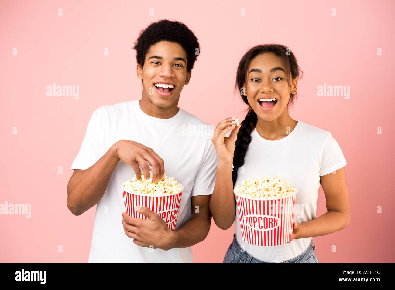 African-american couple eating popcorn and watching comedy film Stock ...
