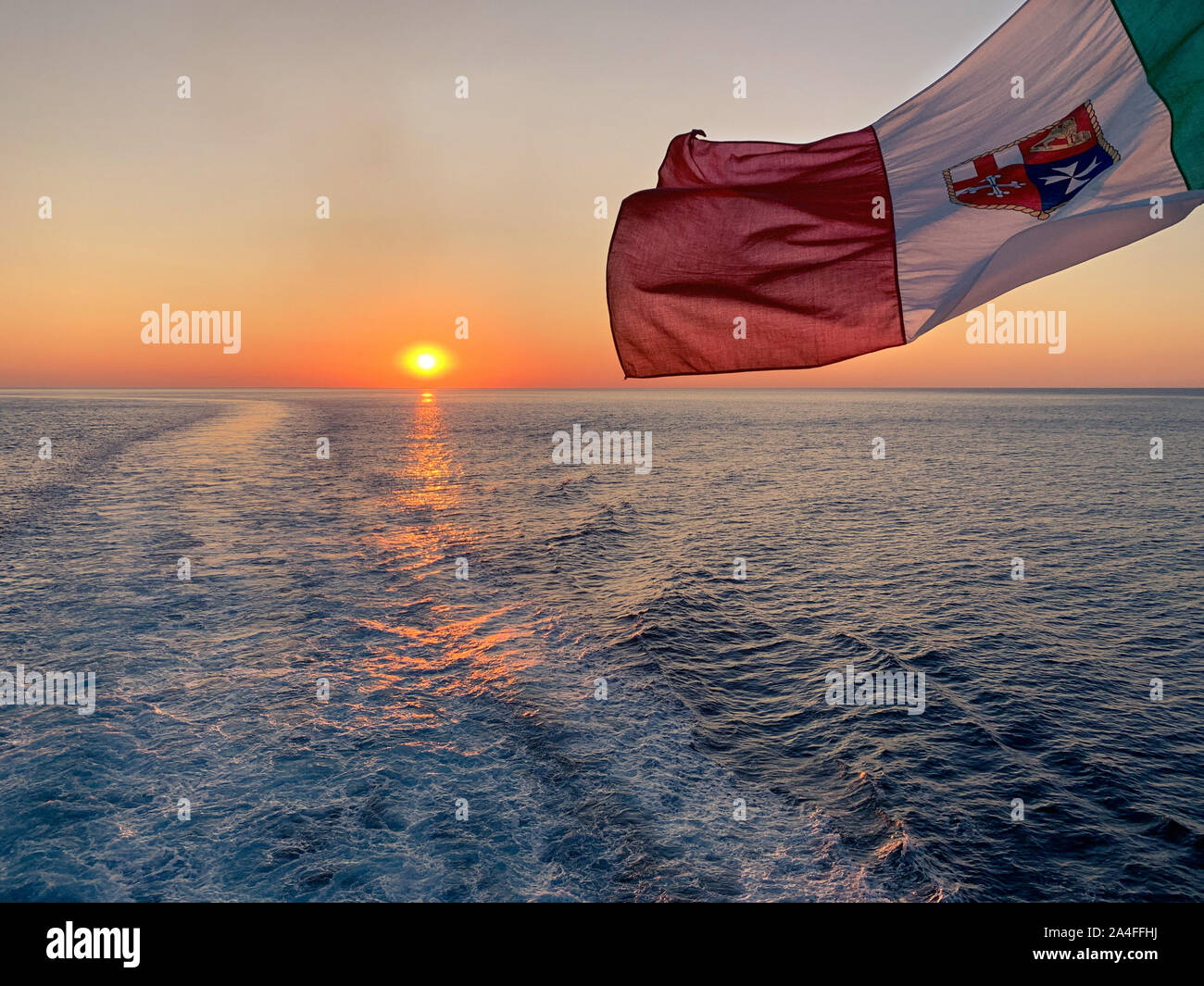 Italian flag waving on a ship sailing at sunset Stock Photo - Alamy