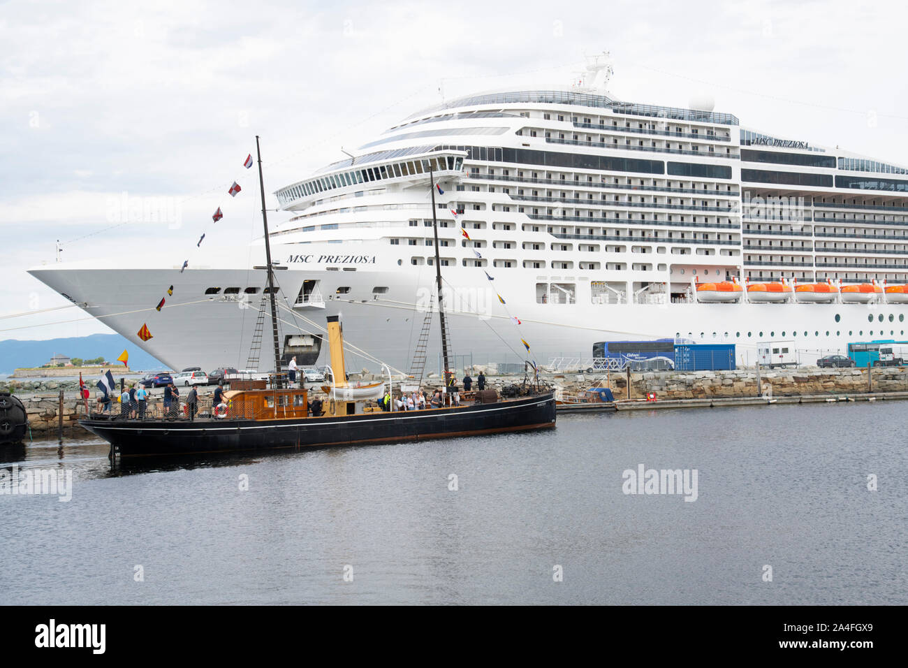 An old steam powered boat next to a huge modern cruise ship in the ...