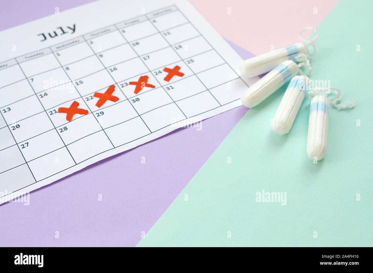 Flat lay composition with calendar and menstrual tampons on blue pink ...