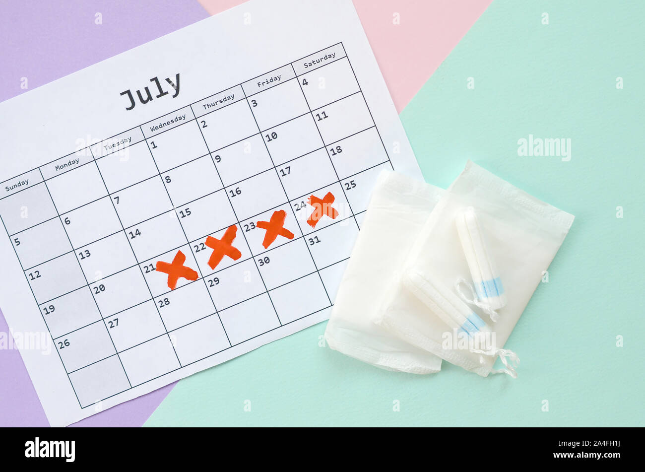 Flat lay composition with calendar and menstrual tampons and pad packs ...
