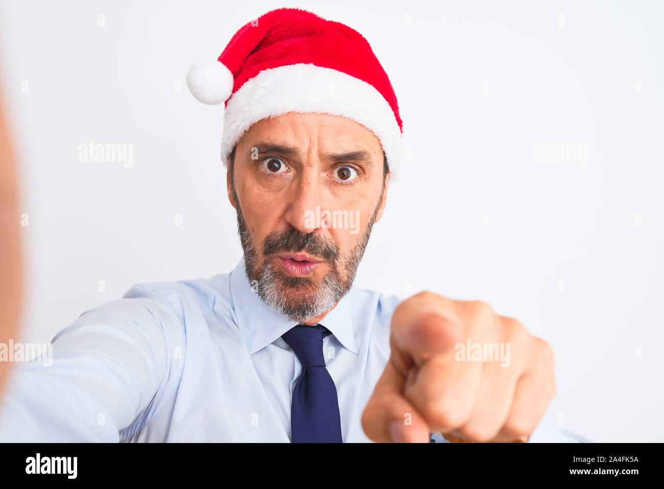 Middle age businessman wearing christmas hat make selfie over isolated ...