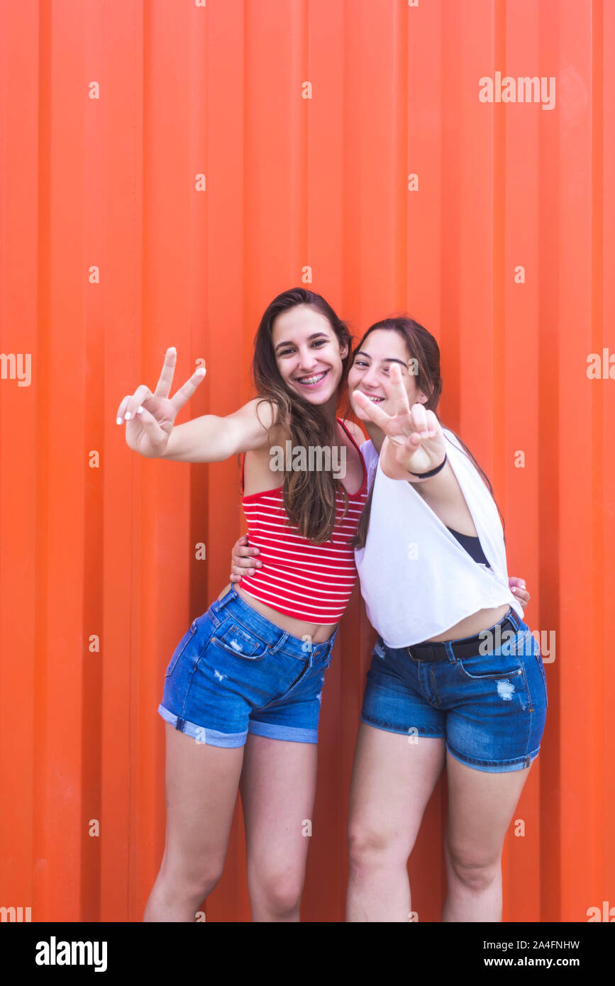 Two happy cheerful teenage girls in showing peace gesture Stock Photo ...