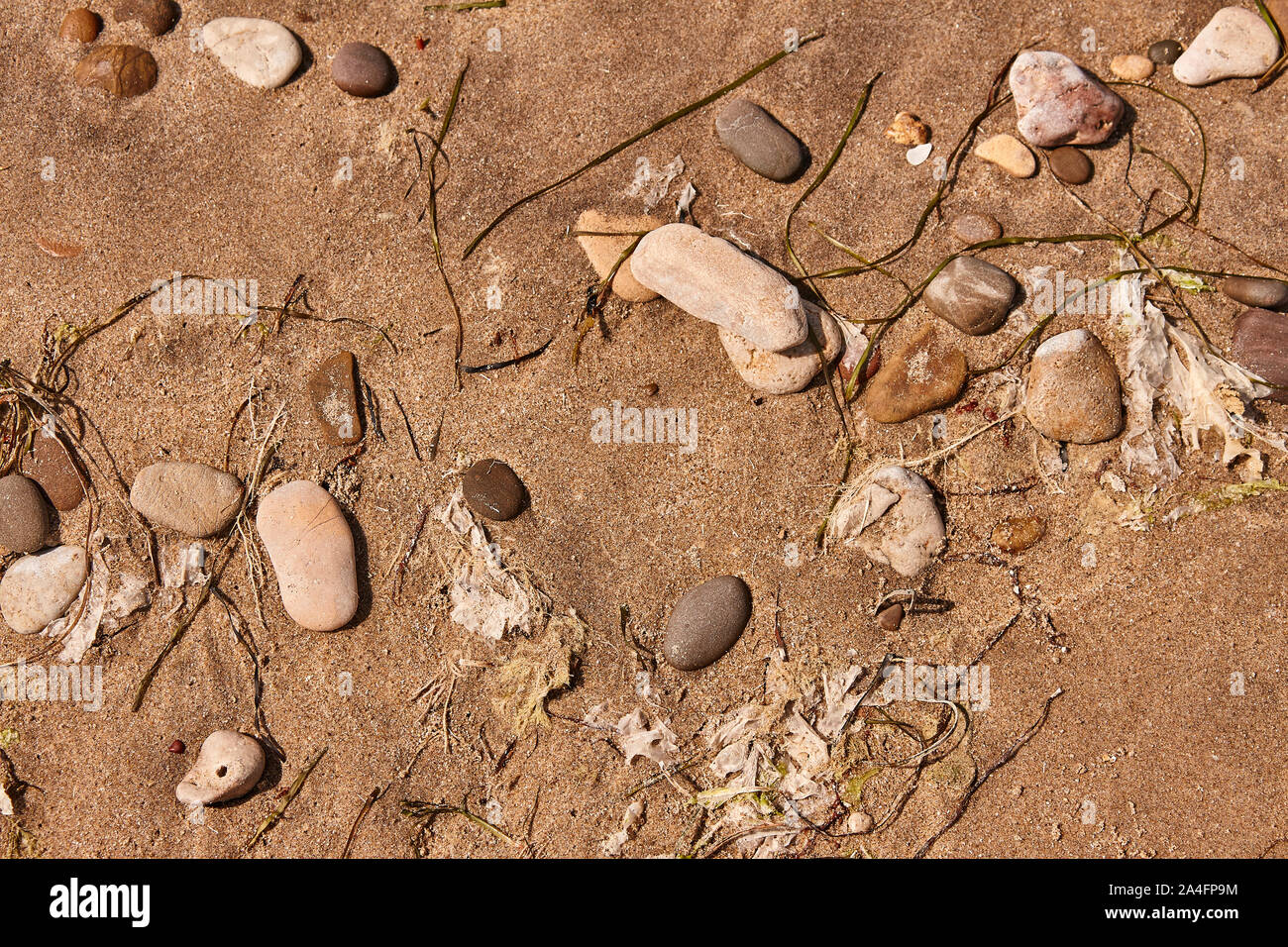 Pebbles on Sand Stock Photo - Alamy