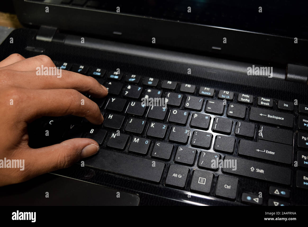 Hacker typing code on laptop keyboard with his fingers Stock Photo - Alamy