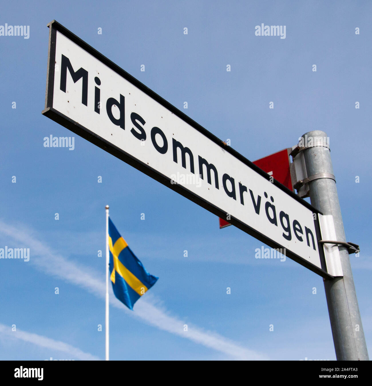 Street sign with the name Midsommarvägen, Swedish flag in the ...