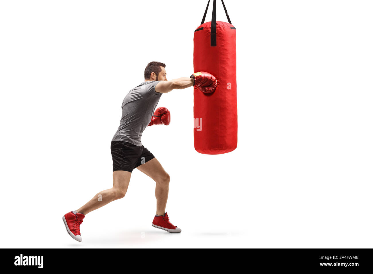 Full length profile shot of a young muscular man training box with a ...