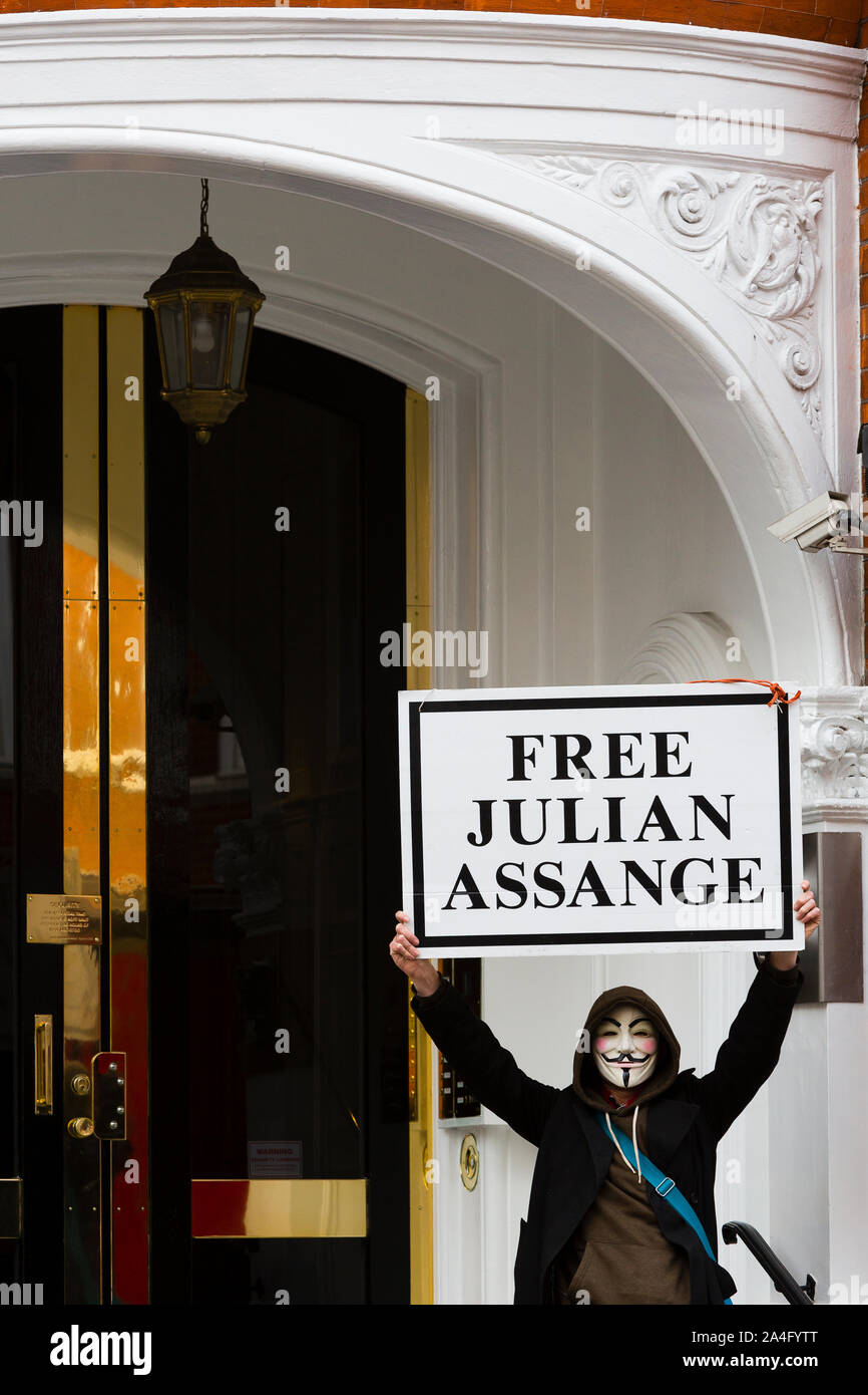 London, UK. A protester in a Guy Fawkes mask holds a "Free Julian ...