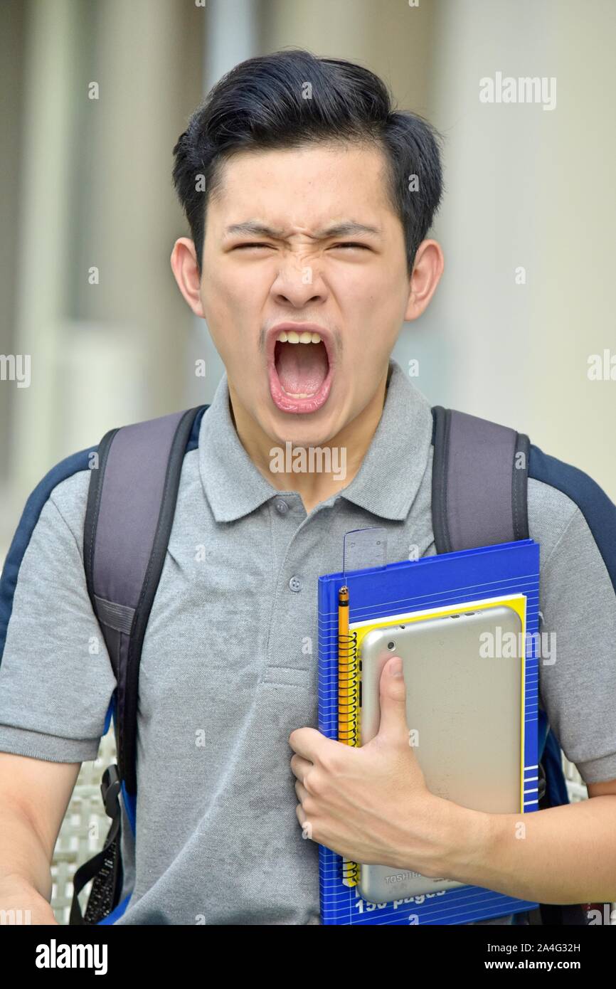 An Angry Male Student With Books Stock Photo - Alamy