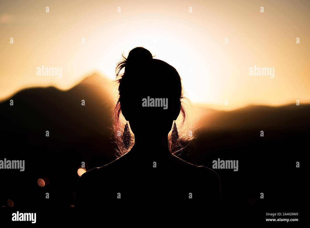 Silhouette of girl's back framing a sunset background Stock Photo - Alamy