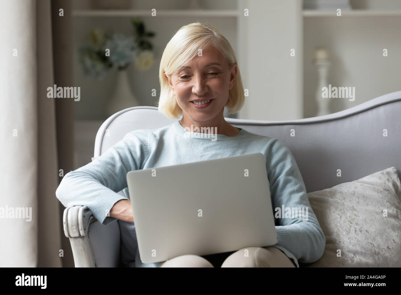 Happy mature lady using computer at home Stock Photo - Alamy
