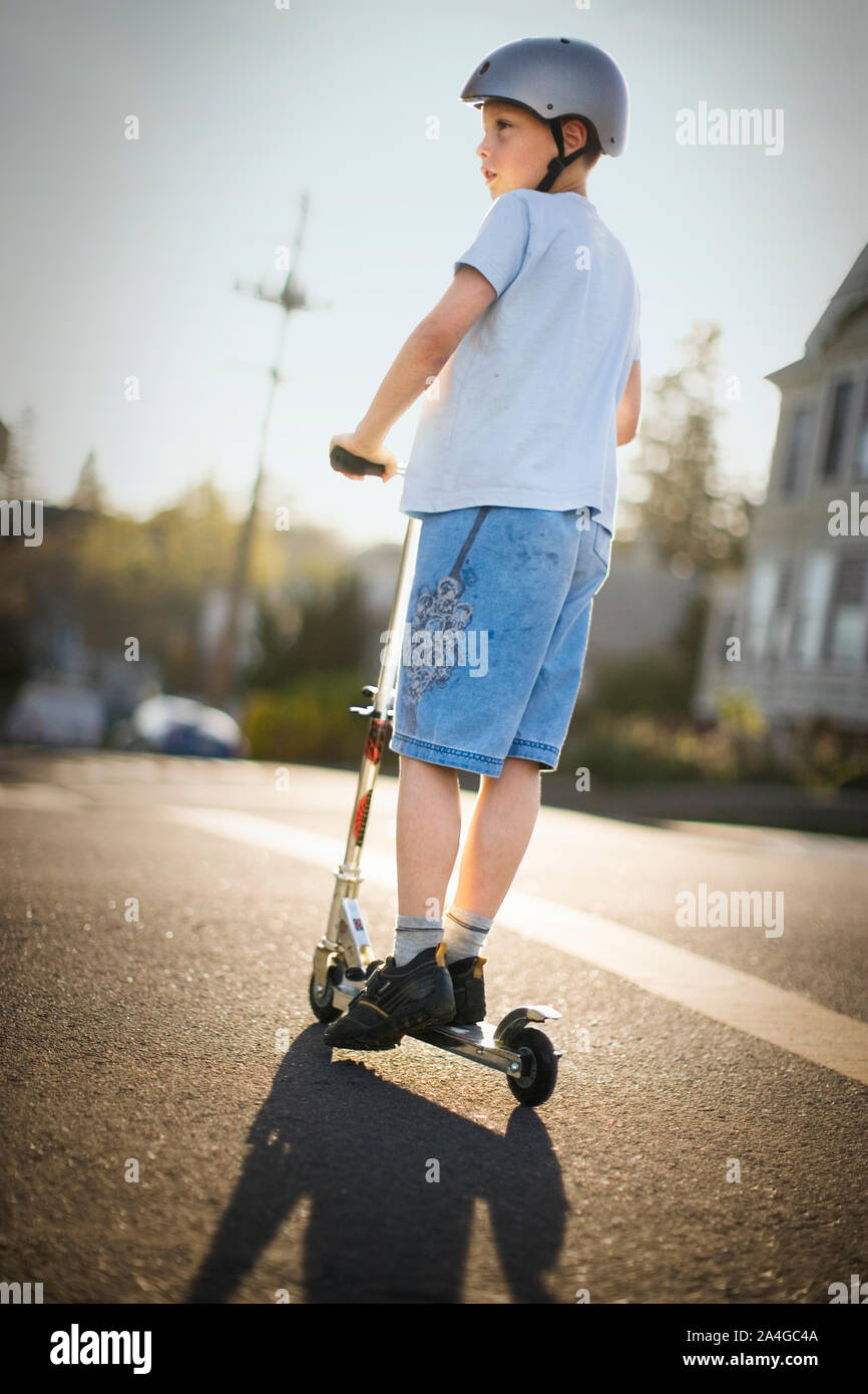 Boy playing with a push scooter outside Stock Photo - Alamy