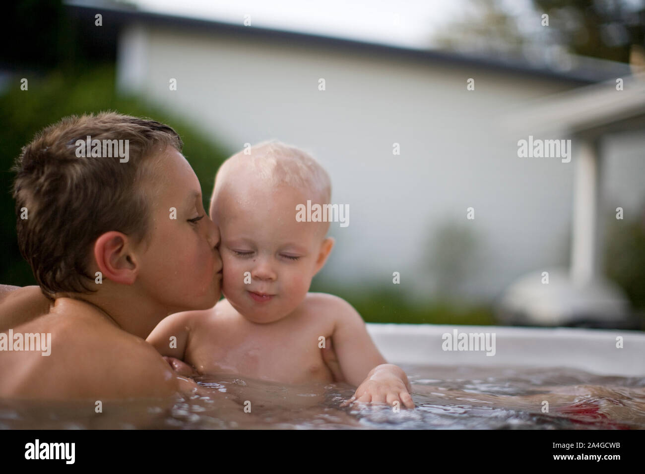 Two brothers swimming in pool hi-res stock photography and images - Alamy