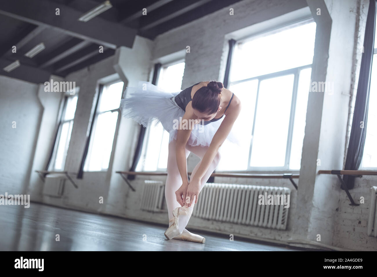 Young ballet dancer practice tying pointe in studio active lifestyle ...