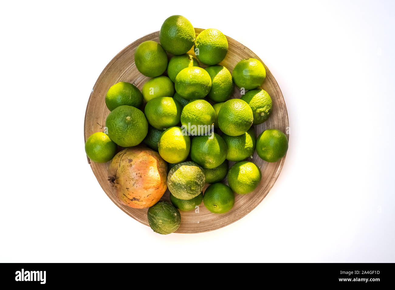 Bowl full of unripe green mandarins isolated on white background viewed ...