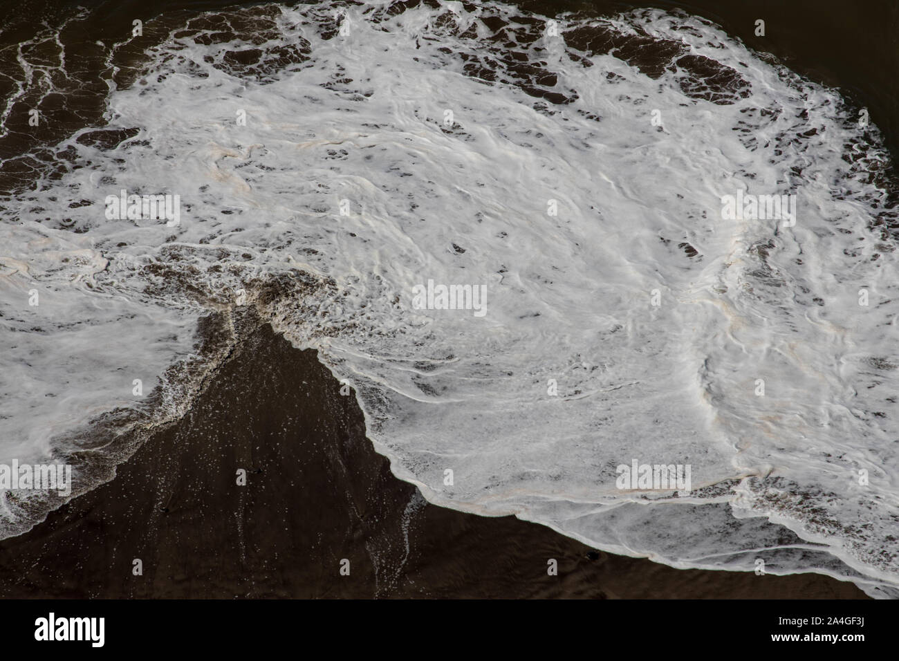 Breaking waves create shape on beach Stock Photo - Alamy