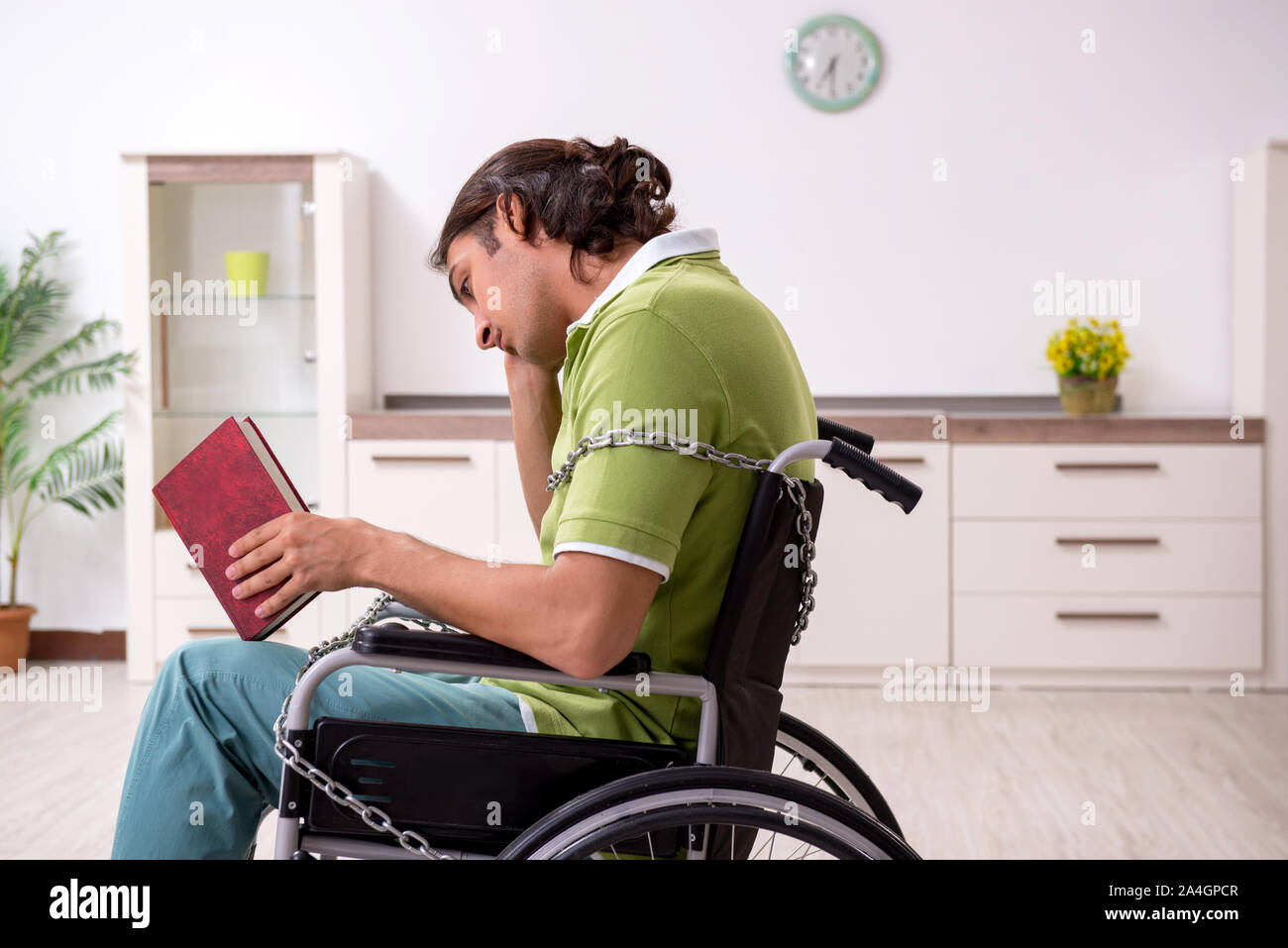 The young male invalid in wheel-chair suffering at home Stock Photo - Alamy