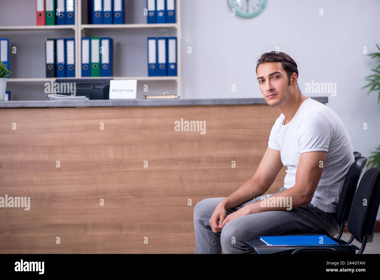 Clinic reception counter and young patient Stock Photo - Alamy