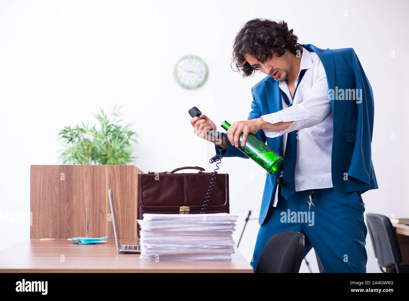 The young drunk employee in the office Stock Photo - Alamy