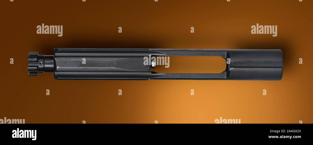 Bottom of an assault rifle bolt carrier group on a brown background ...