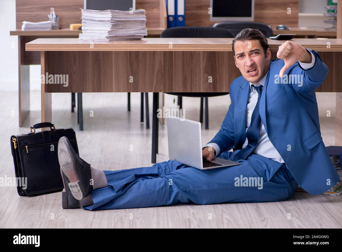 The young male employee and too many work in the office Stock Photo - Alamy