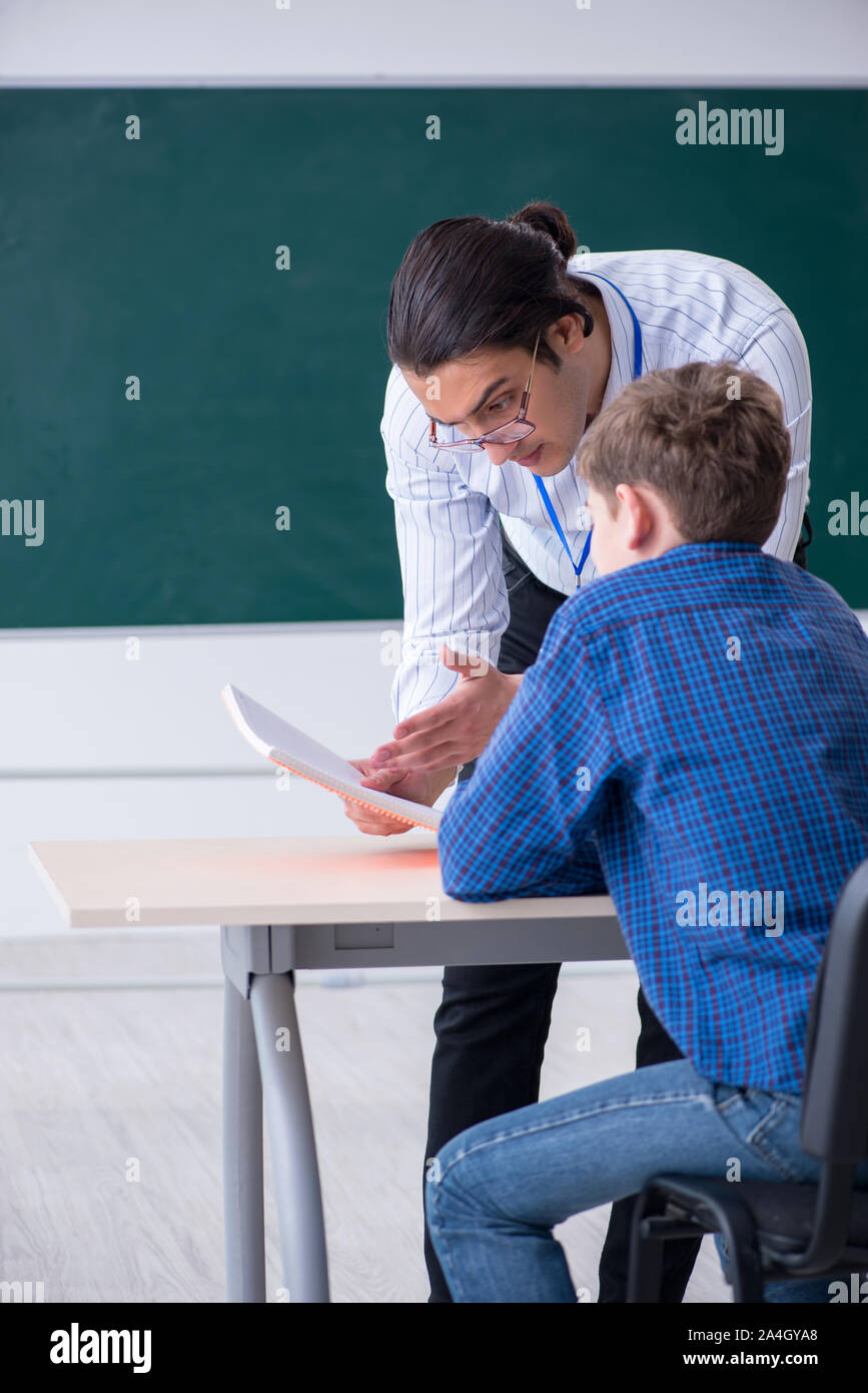 The young male teacher and boy in the classroom Stock Photo - Alamy