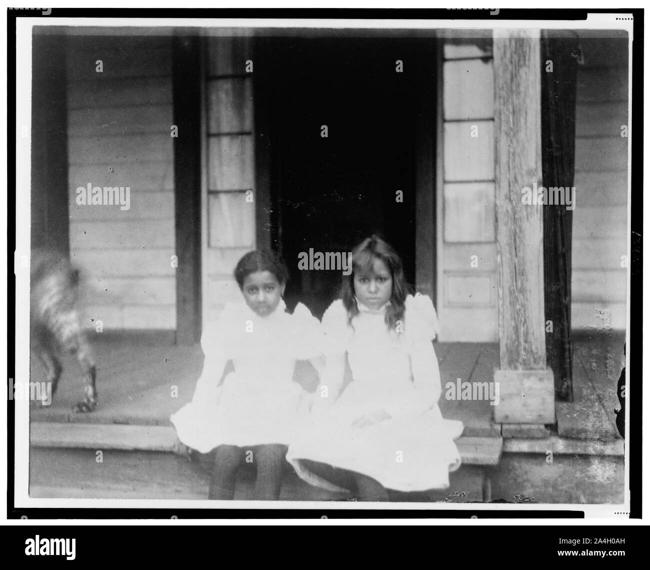 Two African American girls sitting on a porch Stock Photo - Alamy