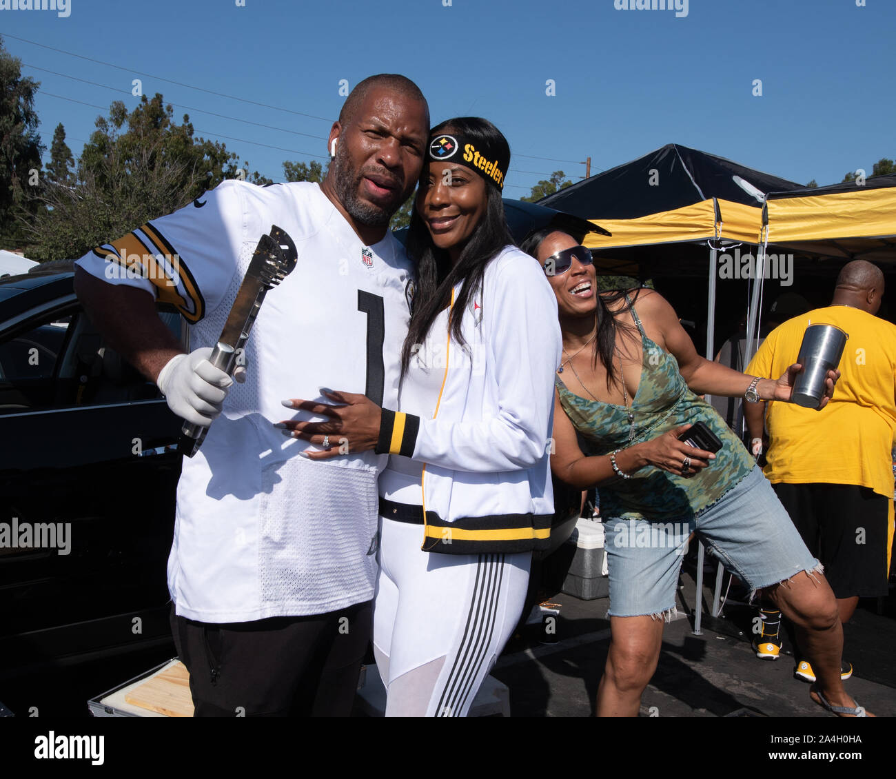 Steeler fans pose for picture at a tailgate party before an NFL ...
