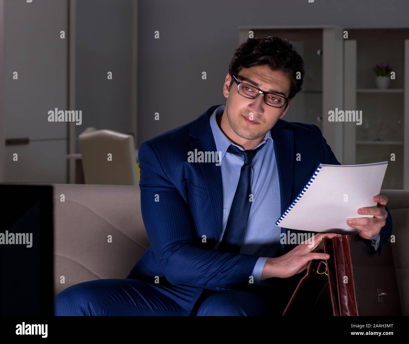 The businessman watching tv at night late Stock Photo - Alamy