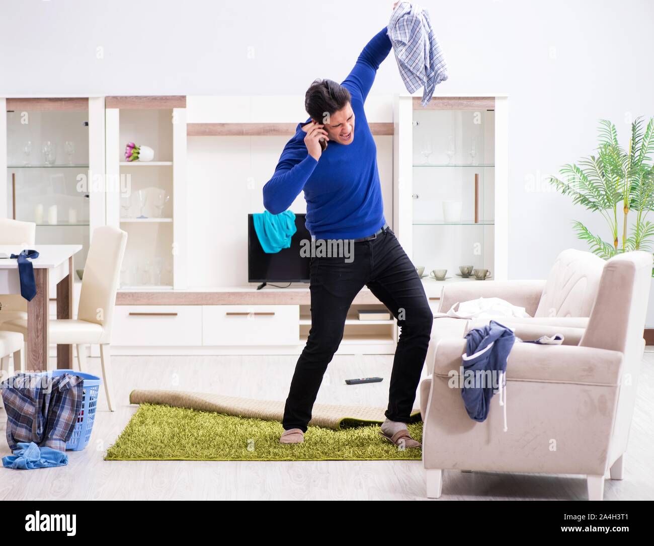 The young man collecting dirty clothing for laundry Stock Photo - Alamy