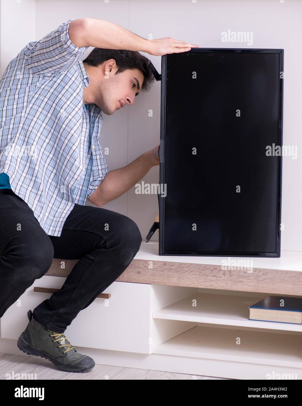 The man repairing broken tv at home Stock Photo - Alamy