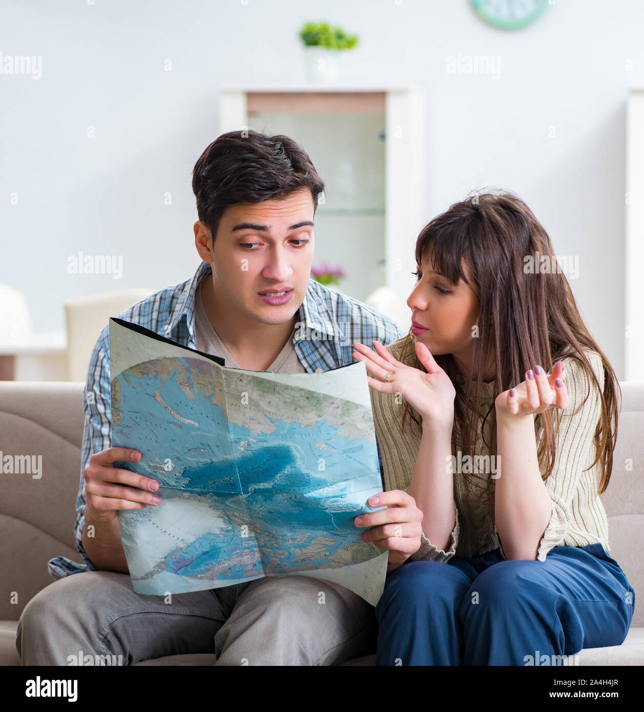 The young family discussing travel plans with map Stock Photo - Alamy