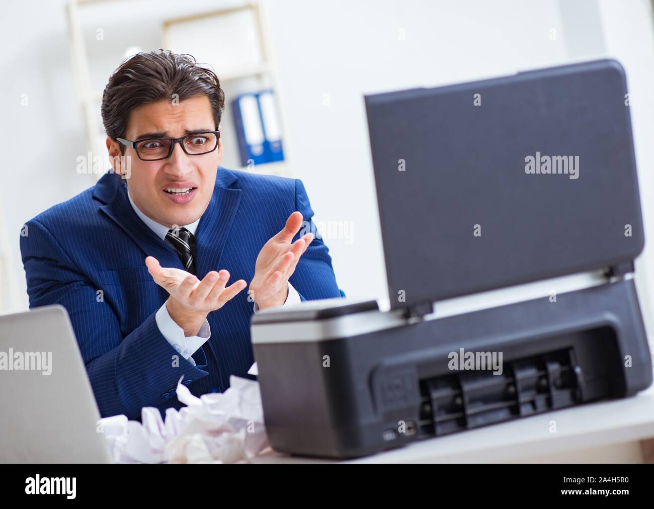 The businessman angry at copying machine jamming papers Stock Photo - Alamy