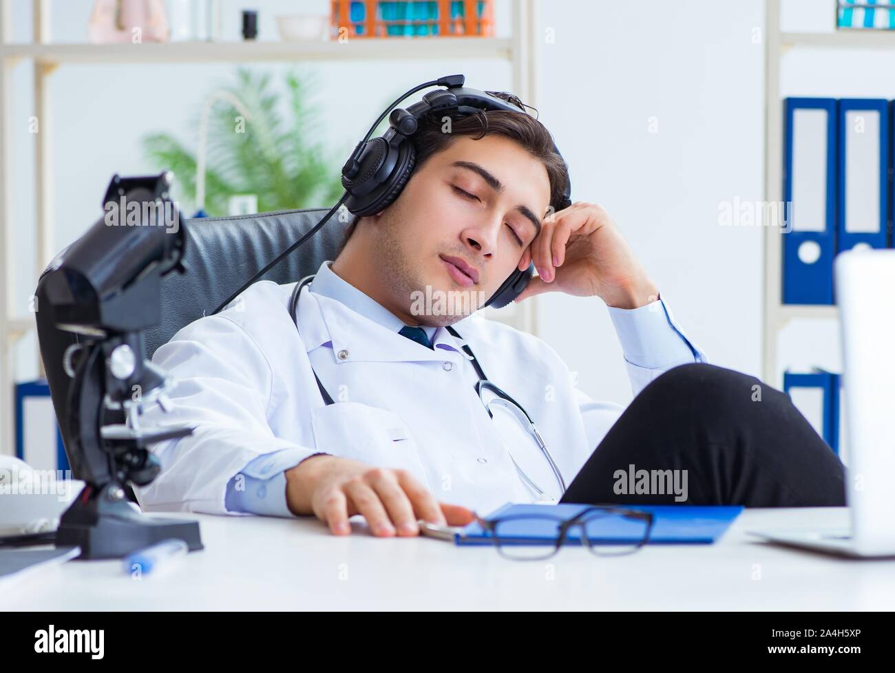 Happy excited doctor listening to music during lunch break in hospital ...